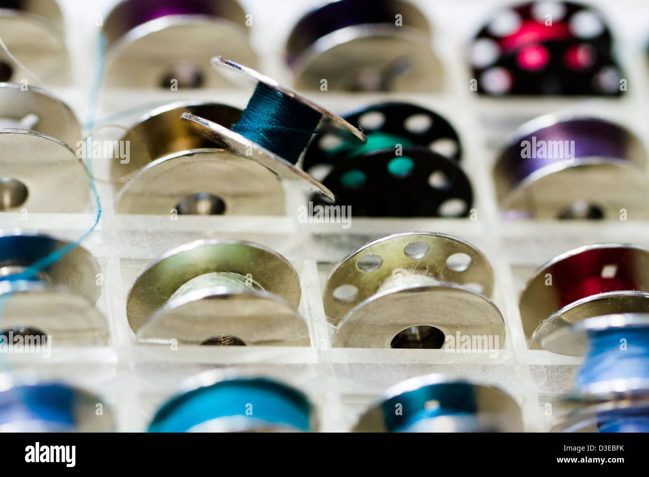 Colorful bobbins of thread in bobbin box in tailor shop Stock Photo - Alamy