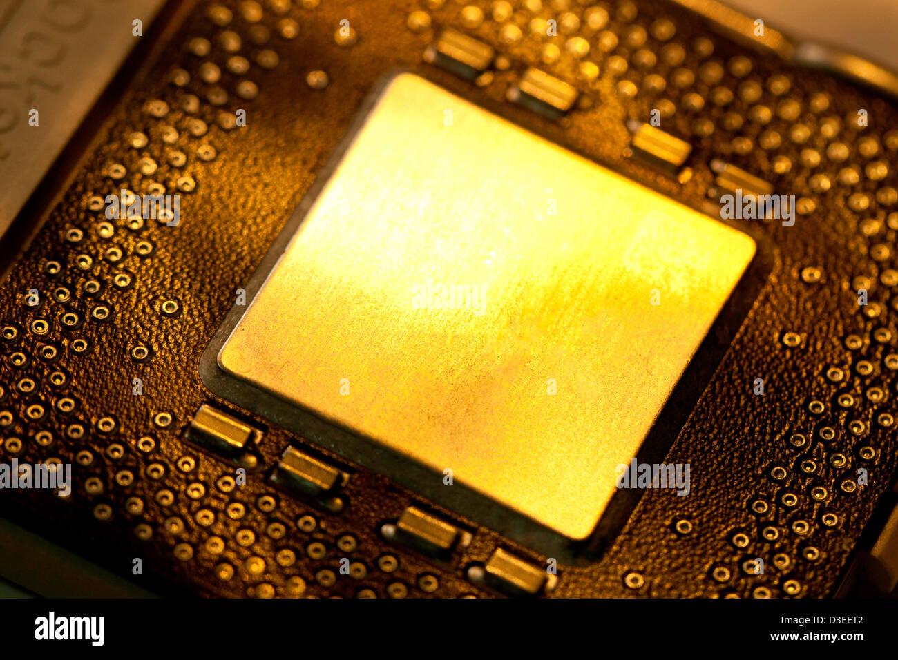 Close view detail of a computer microprocessor with a golden light ...