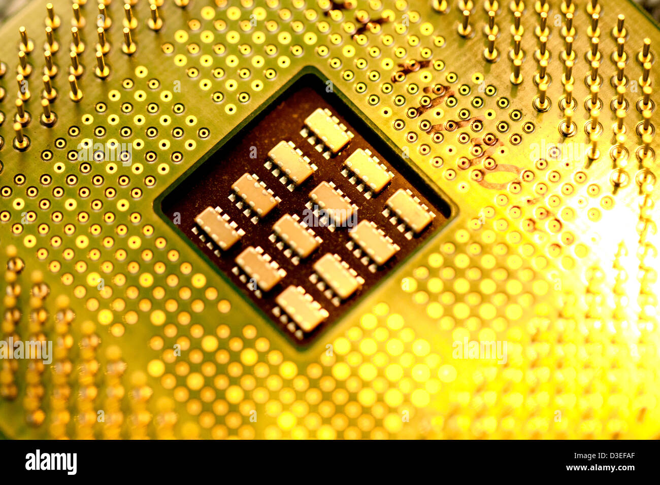 Close view detail of a computer microprocessor with a golden light ...