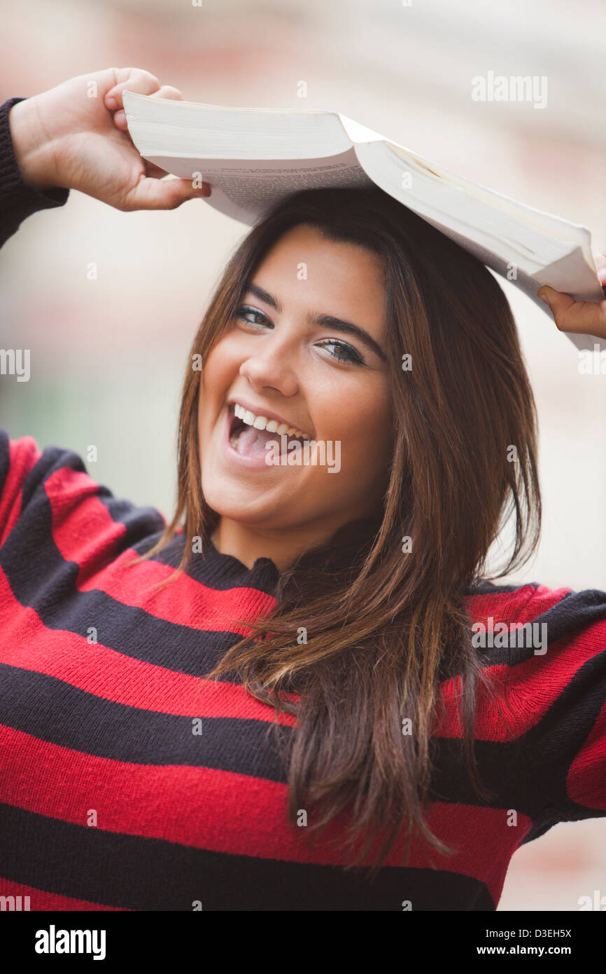 Portrait of a overweight woman putting book on her head and smiling ...