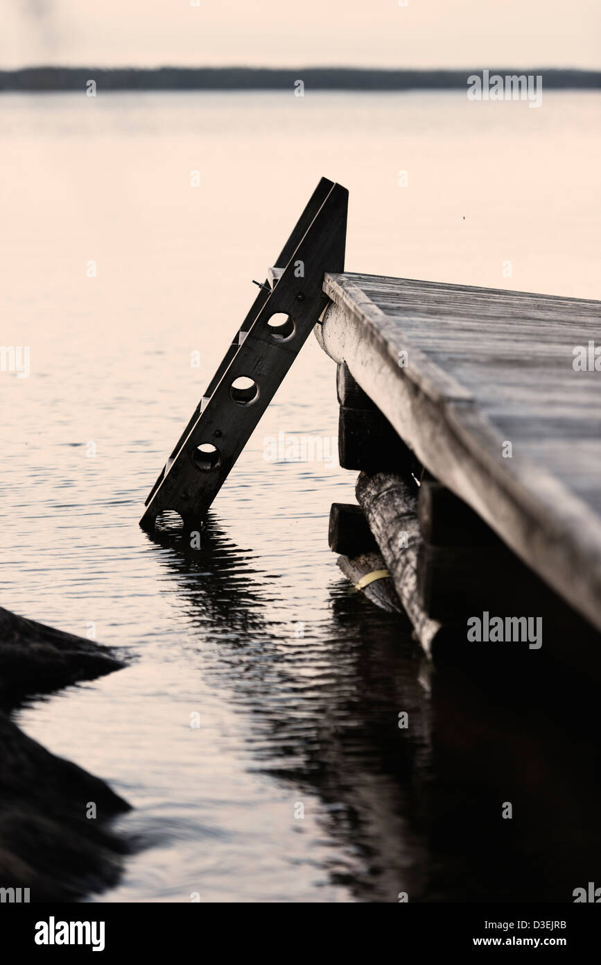 Tranquil evening scene of the sea and wooden jetty with step ladder in ...