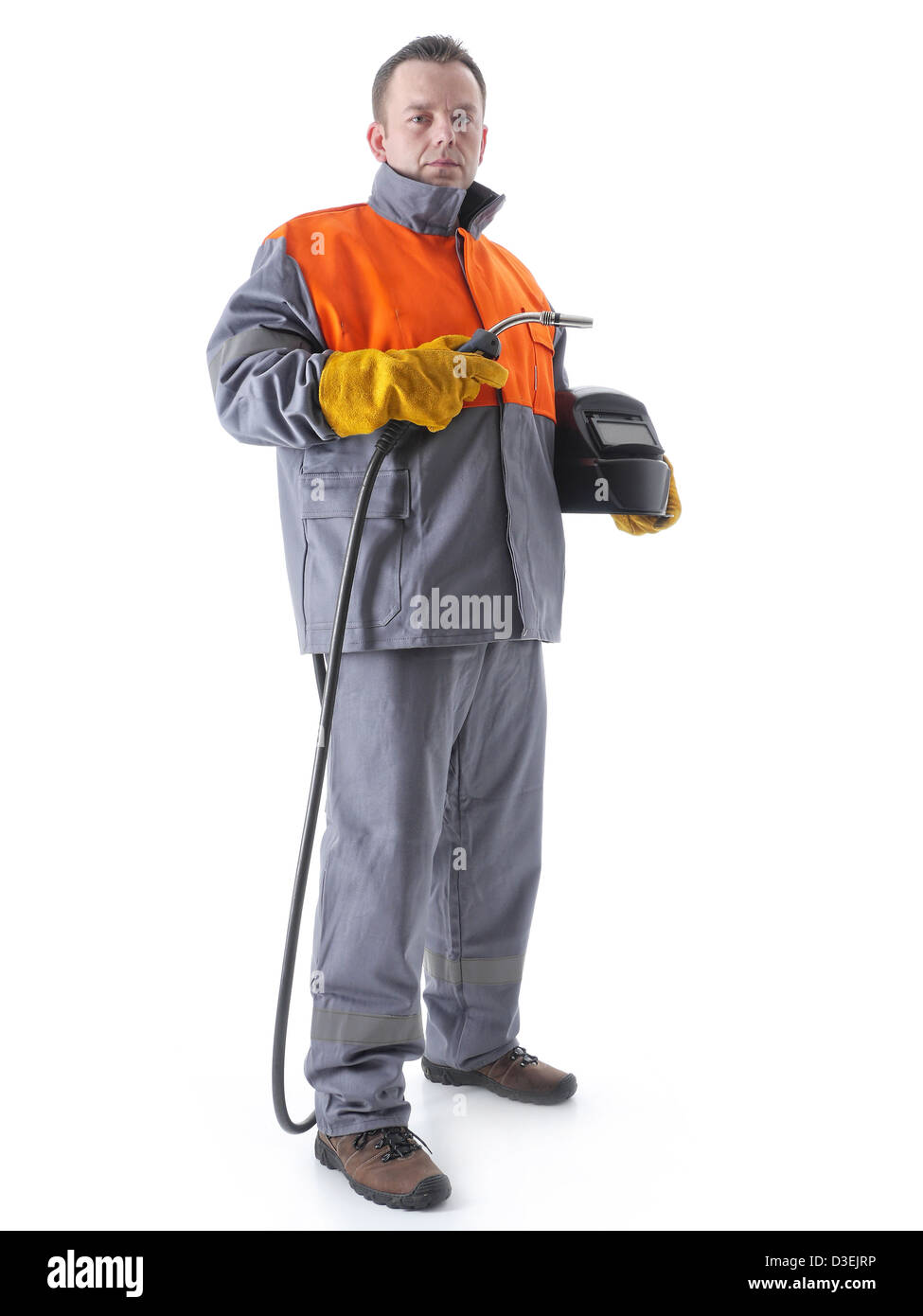 Welder wearing protective suit holding welding hood and gas welding gun ...