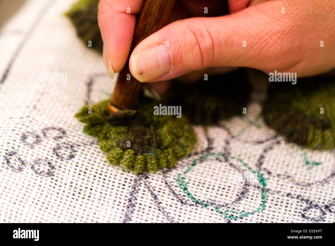 Hands work a hook in hug hooking craft Stock Photo - Alamy