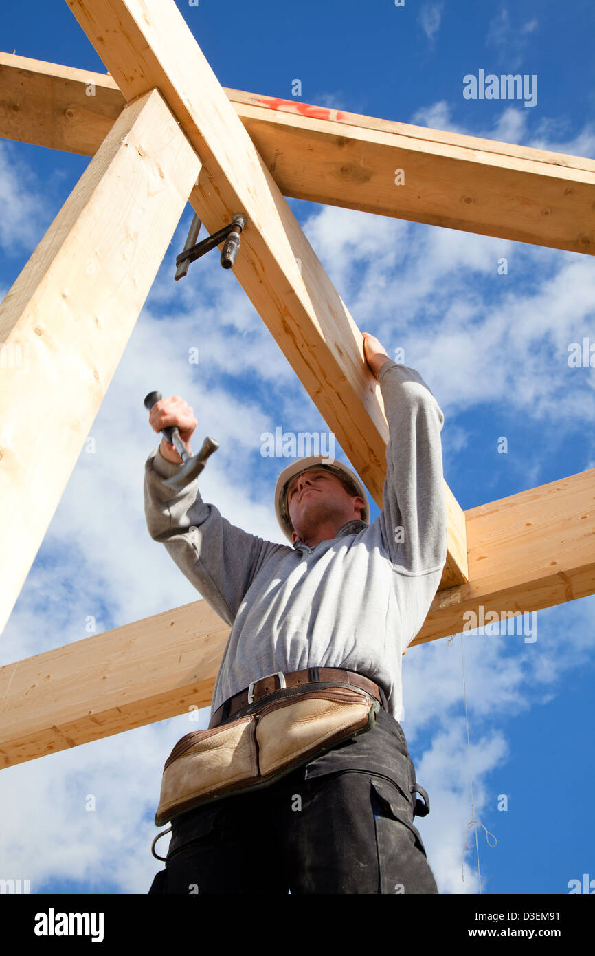 real builder at work with roof construction on building site Stock ...