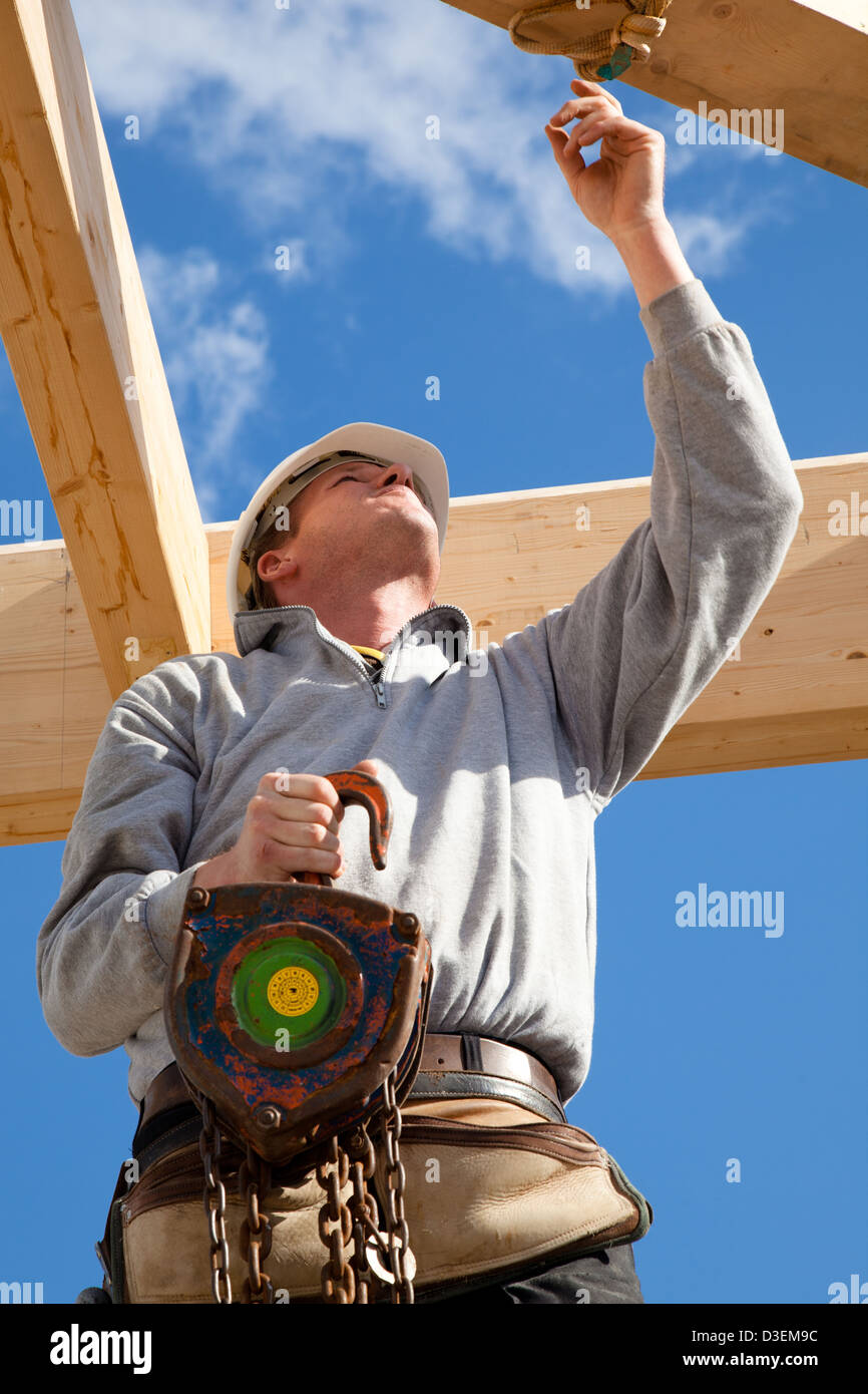 real builder at work with roof construction on building site Stock ...