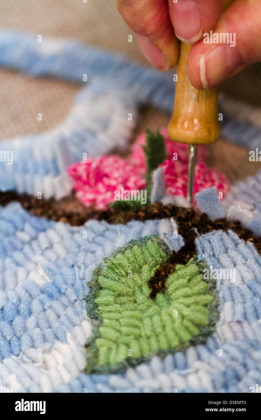 Hands work a hook in hug hooking craft Stock Photo - Alamy