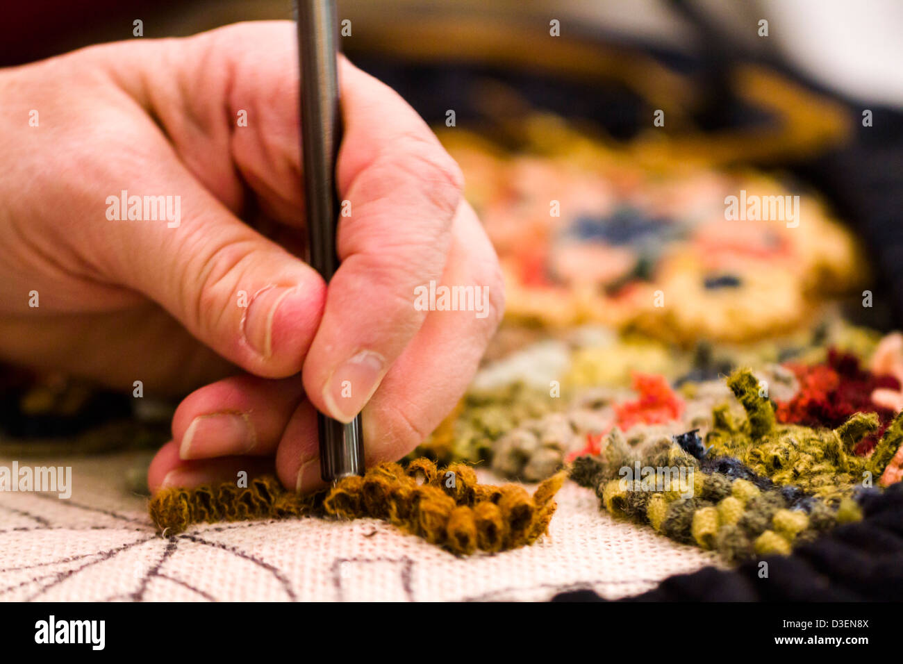 Hands work a hook in hug hooking craft Stock Photo - Alamy