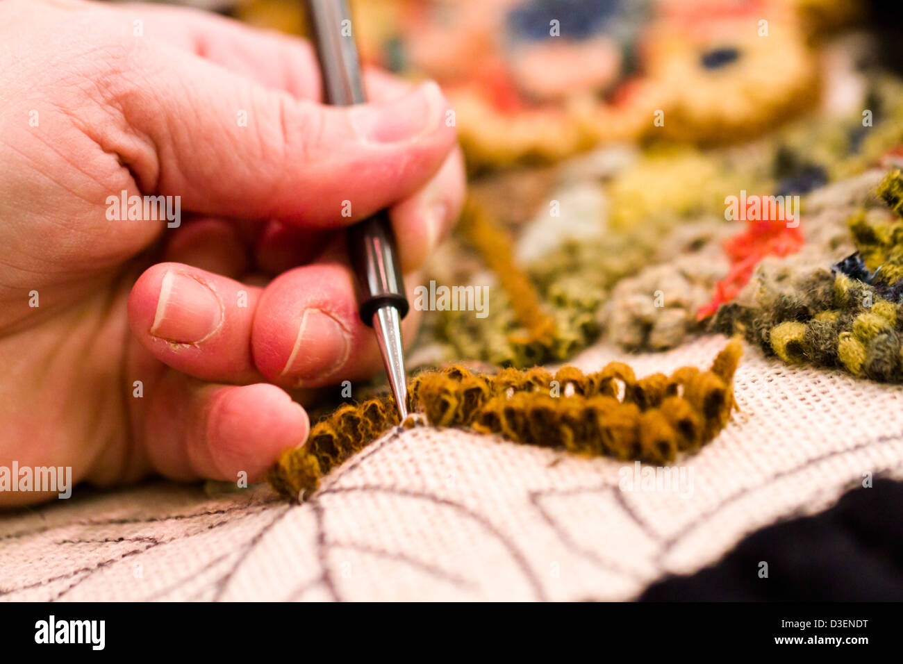 Hands work a hook in hug hooking craft Stock Photo - Alamy