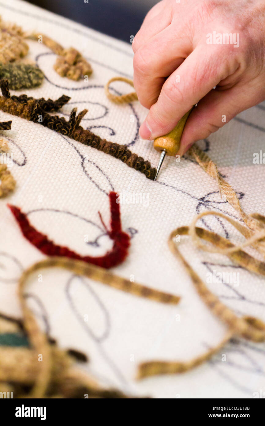 Hands work a hook in hug hooking craft Stock Photo - Alamy