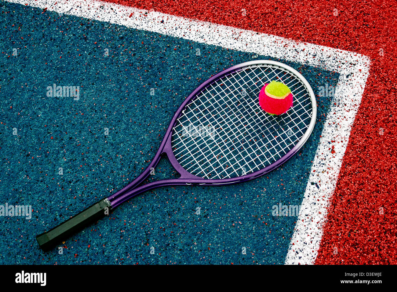 Tennis colored ball and racket, placed in the corner of a synthetic ...