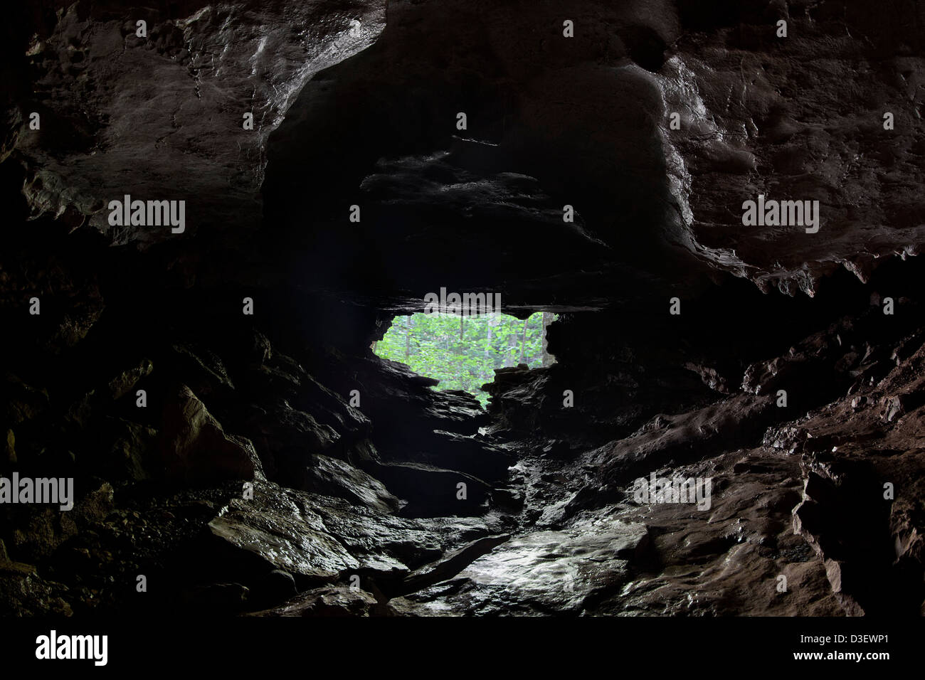 Inside a dark wet cave with the illuminated exit in sight Stock Photo ...