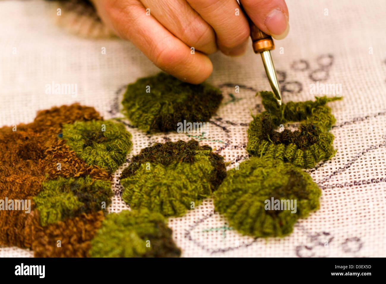 Hands work a hook in hug hooking craft Stock Photo - Alamy