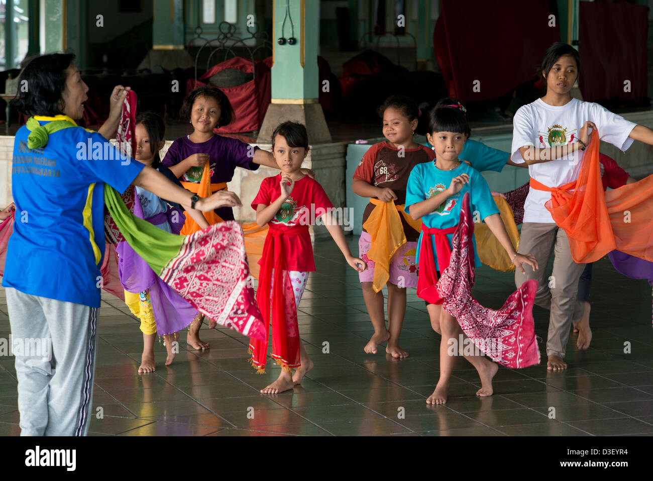 A dance teacher leads a group of young, Javanese students in ...