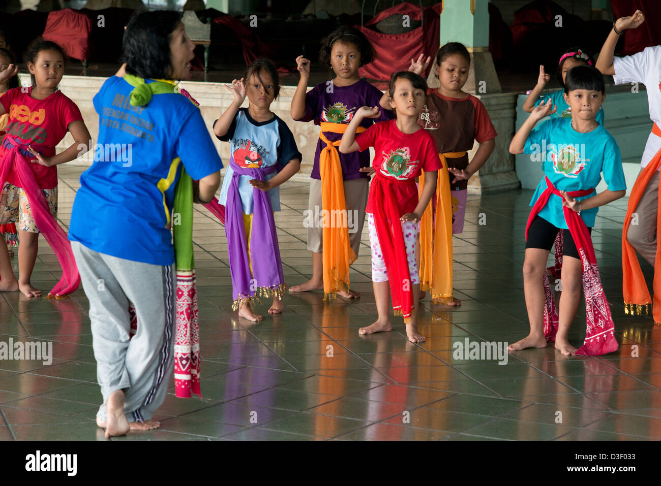 A dance teacher leads a group of young, Javanese students in ...