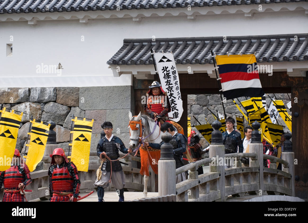 Samurai warriors wearing traditional armor crossing moat bridge at ...