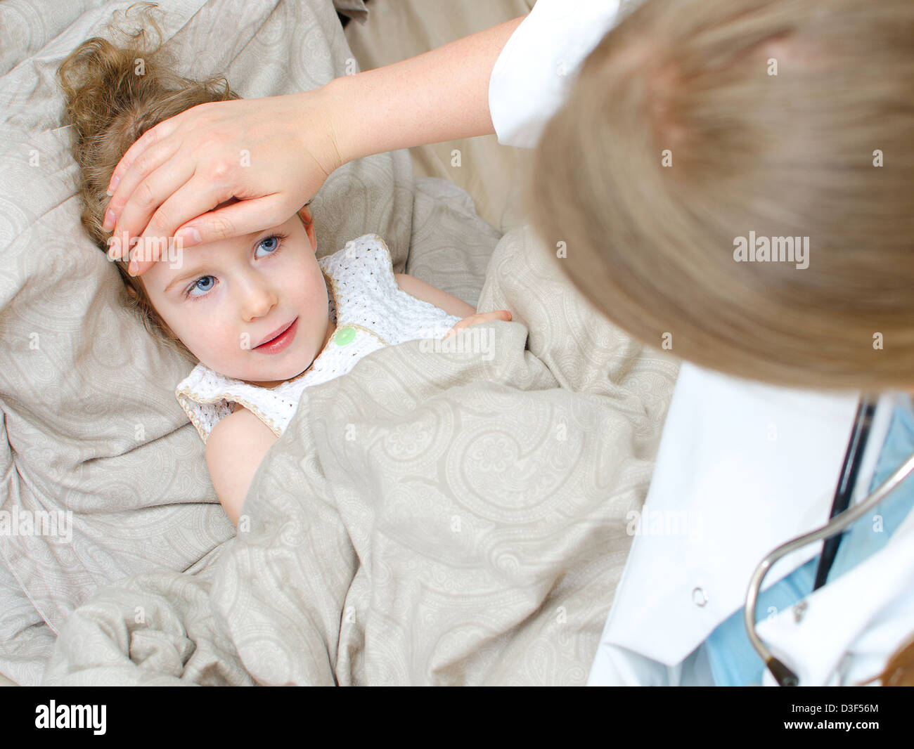 Top view of sick child lying in bed and visiting her doctor Stock Photo ...