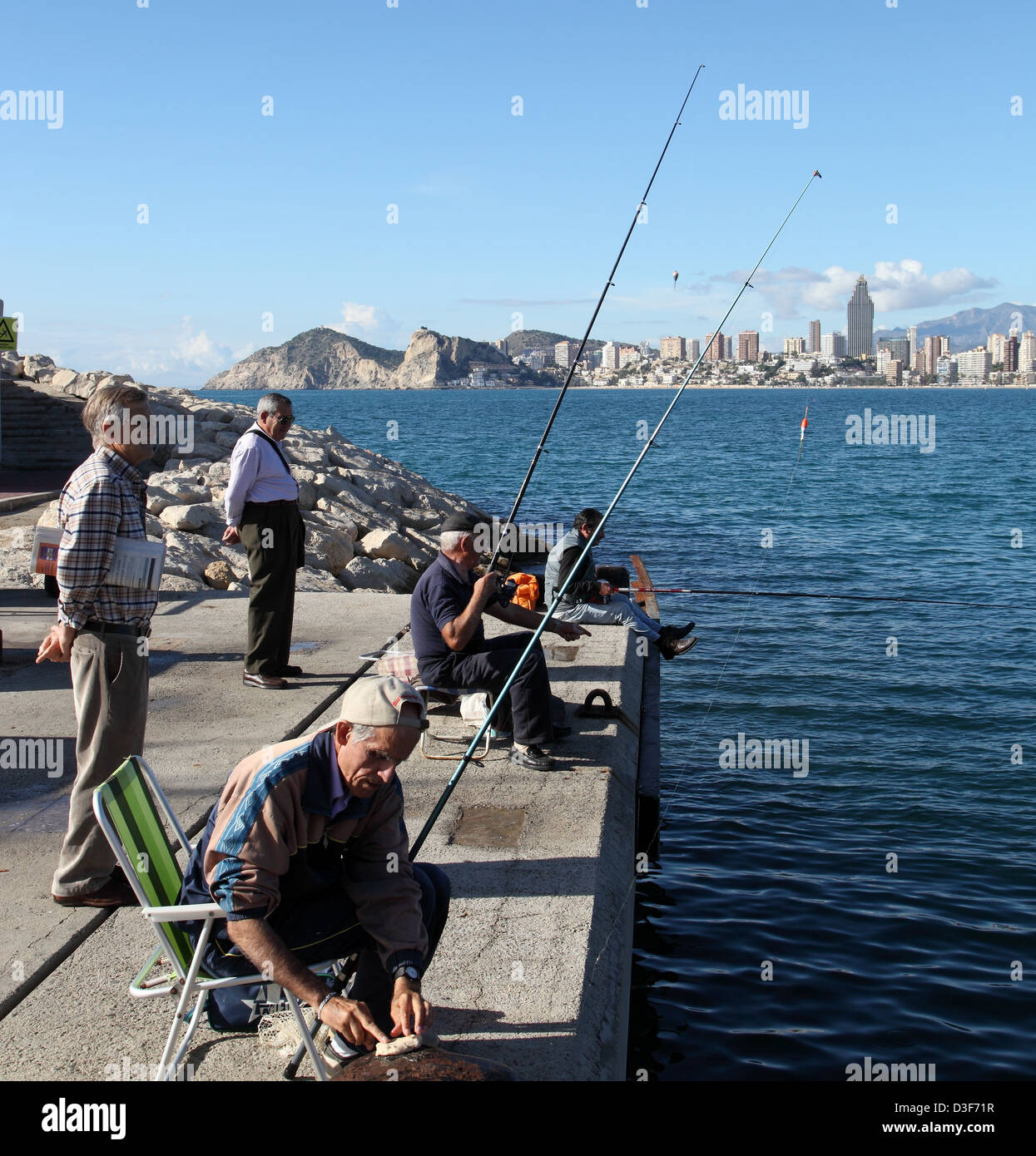Old men sea fishing off harbour in Benidorm Old Town with two old men ...