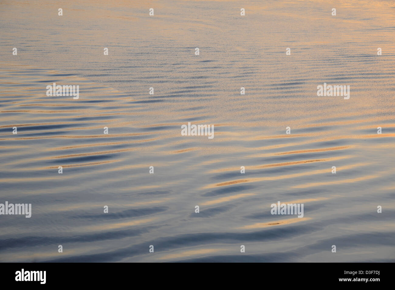 Blue water ripples with sunset reflection Stock Photo - Alamy