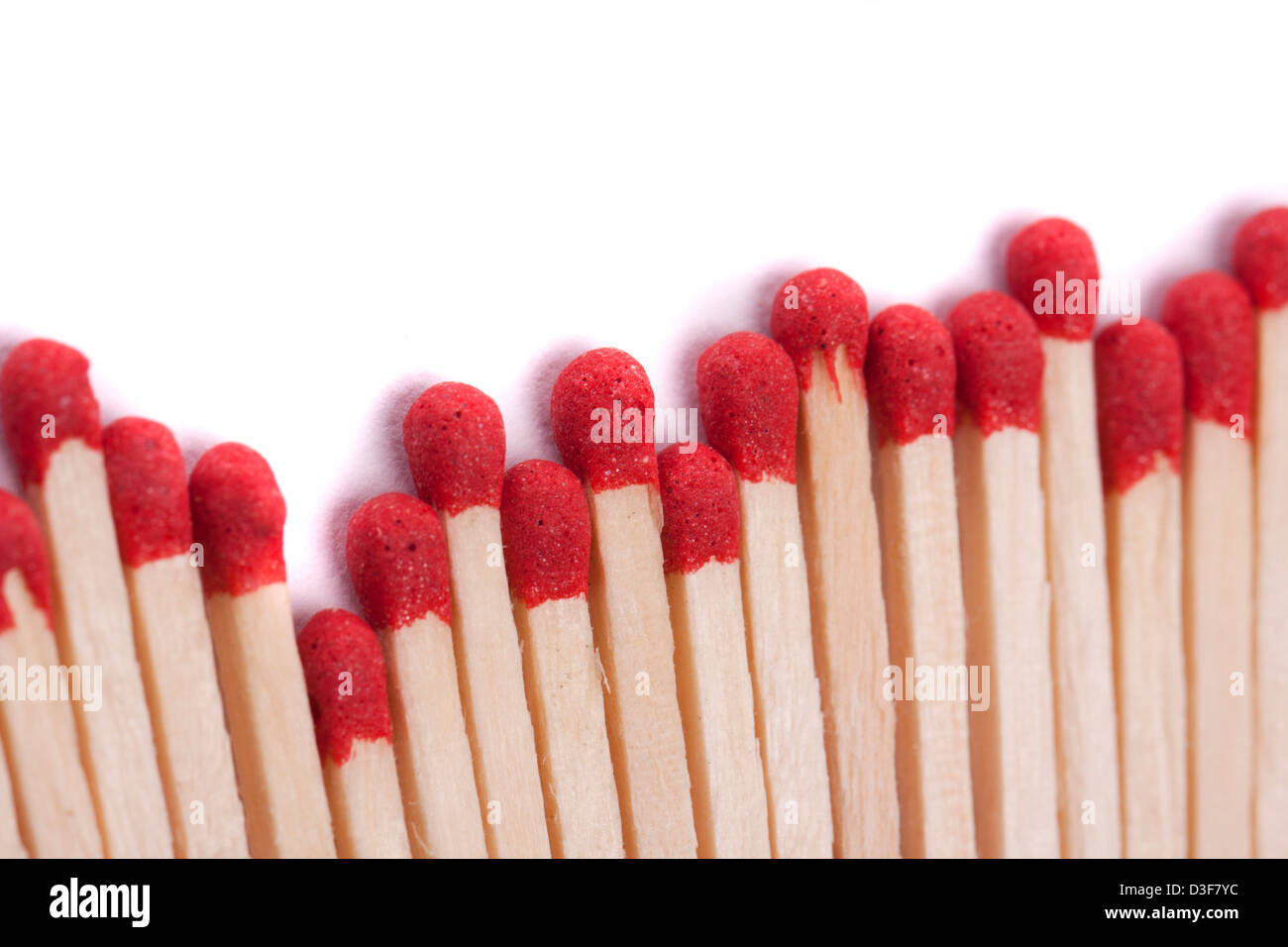 Close up view of a bunch of matches with red heads on a white ...