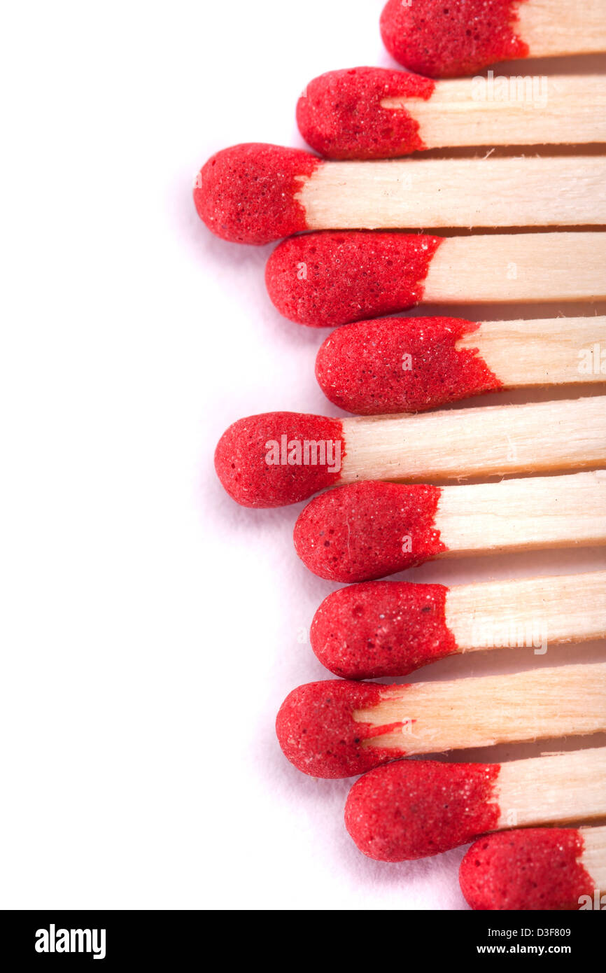 Close up view of a bunch of matches with red heads on a white ...