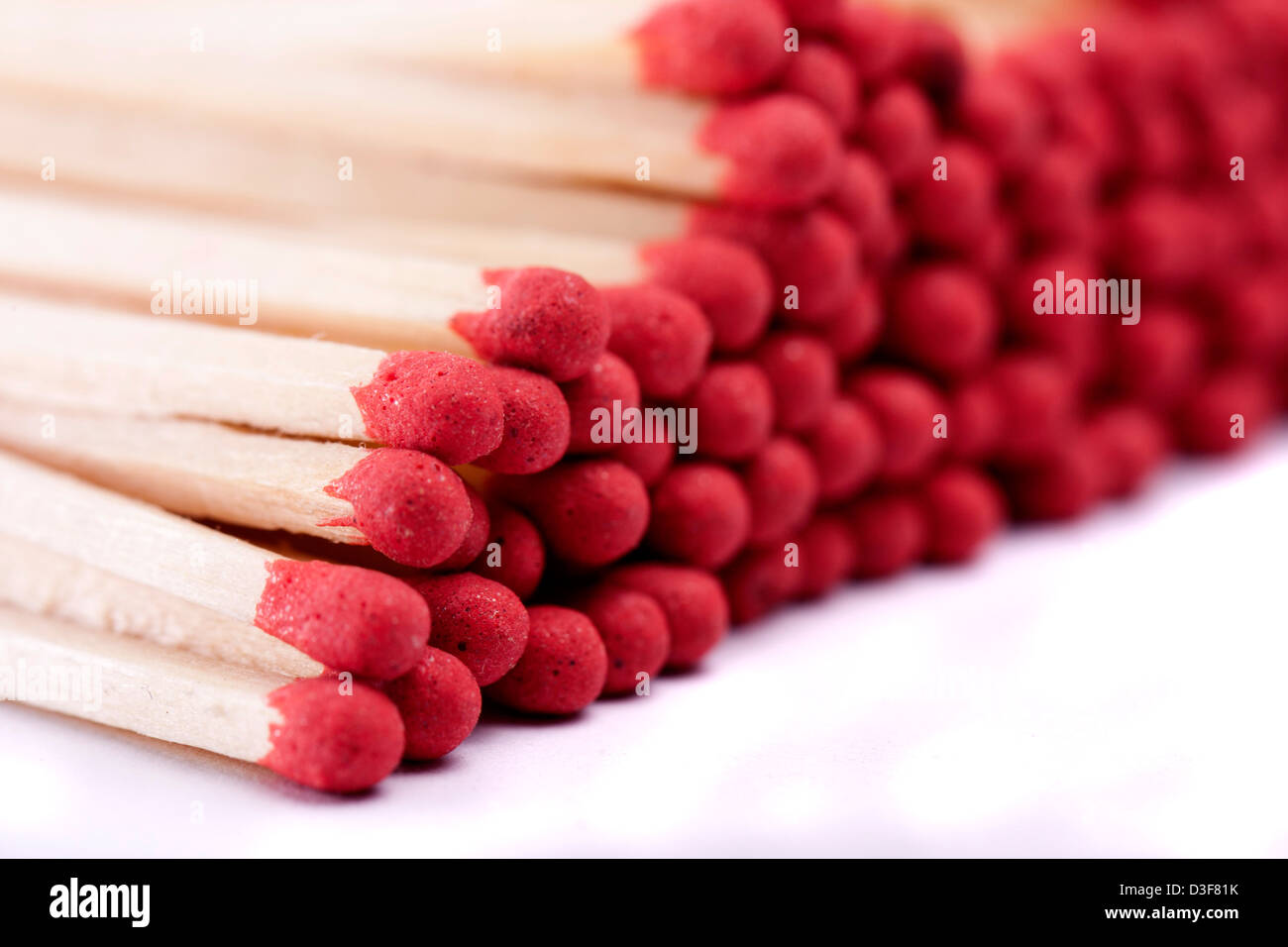 Close up view of a bunch of matches with red heads on a white ...
