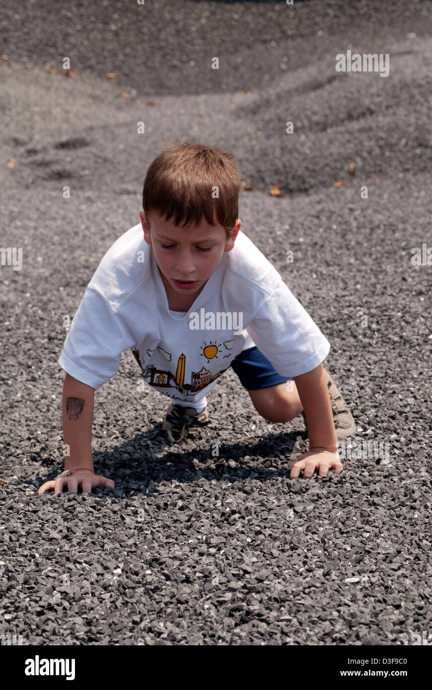 autistic boy at play on a large gravel slope Stock Photo - Alamy