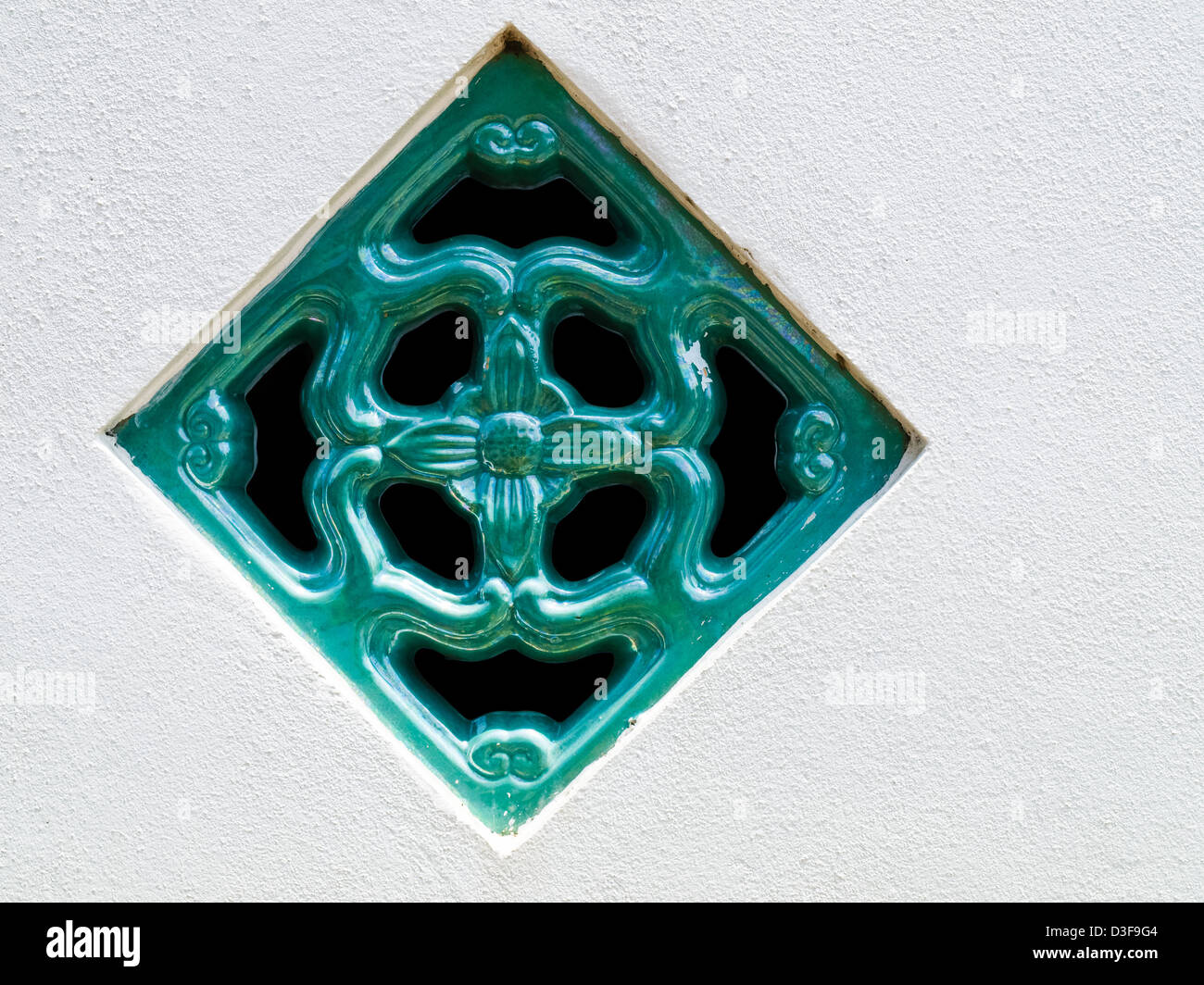 Green Chinese ventilation tile on the white wall Stock Photo - Alamy