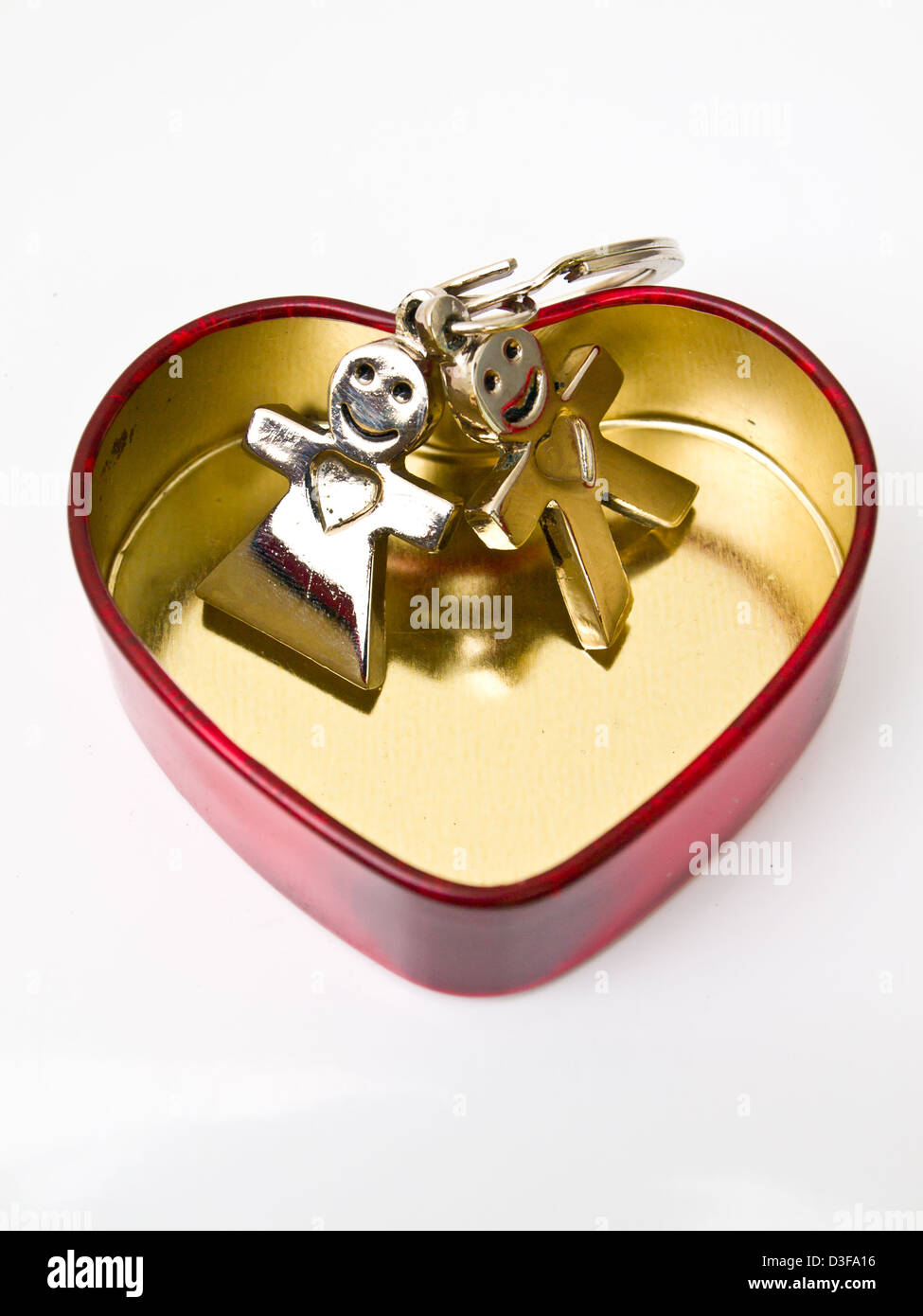 A golden stainless steel heart with a miniature heart keychain isolated ...