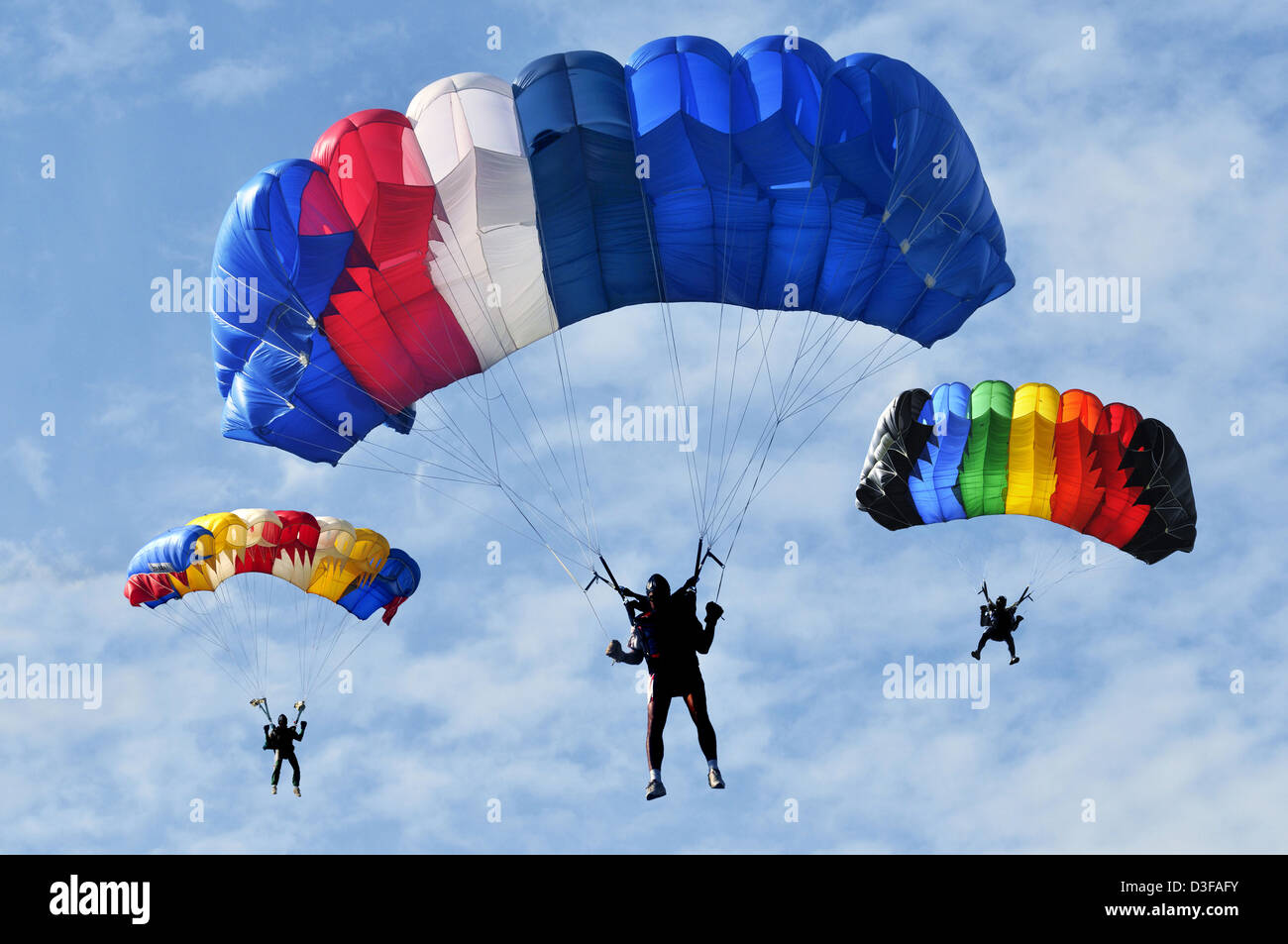 Three colorful parachutes on blue sky Stock Photo - Alamy