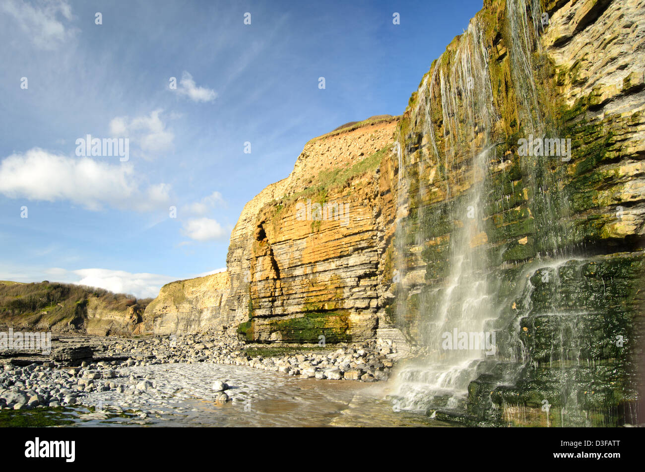 Waterfall over cliffs at Dunraven Bay, Southerndown, South Wales, UK ...