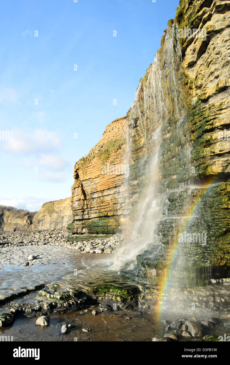 Waterfall over cliffs at Dunraven Bay, Southerndown, South Wales, UK ...