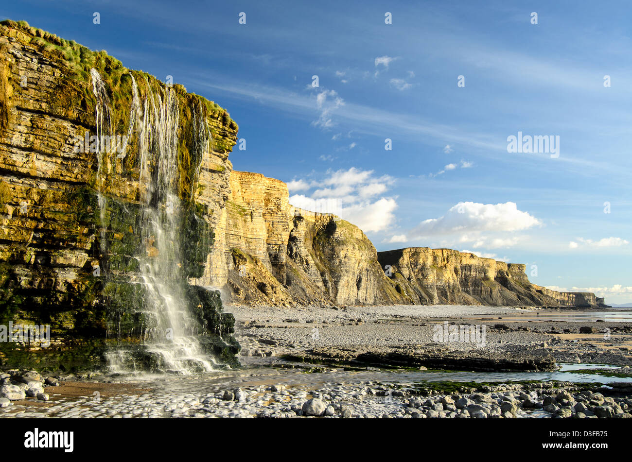 Waterfall over cliffs at Dunraven Bay, Southerndown, South Wales, UK ...