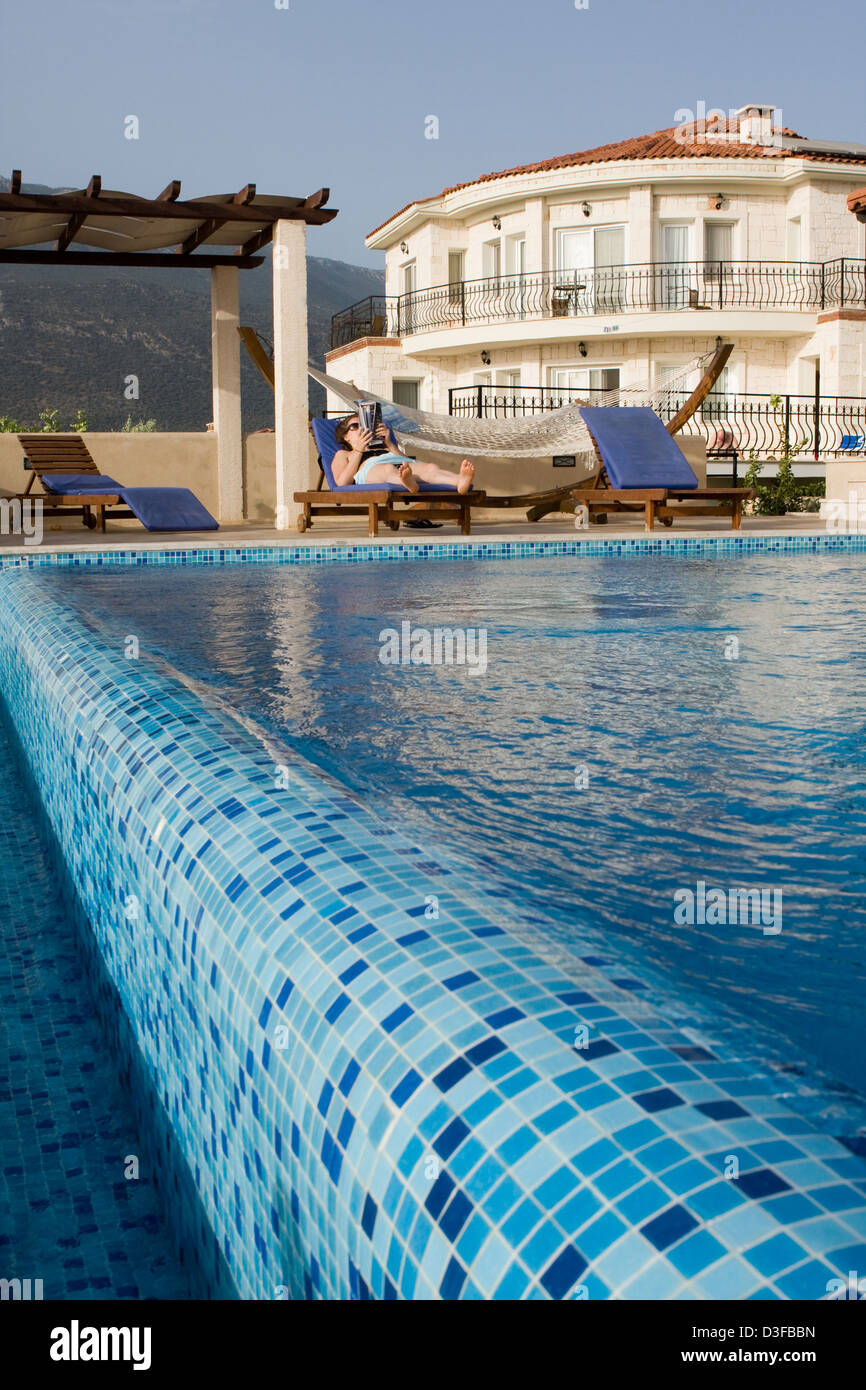 Girl relaxing by an infinity pool outside a Turkish villa Stock Photo ...