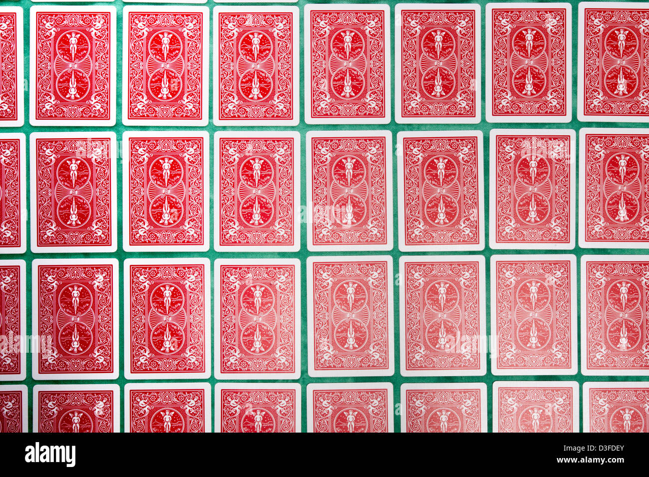 Close up view of a bunch of flipped playing cards spread on a green ...