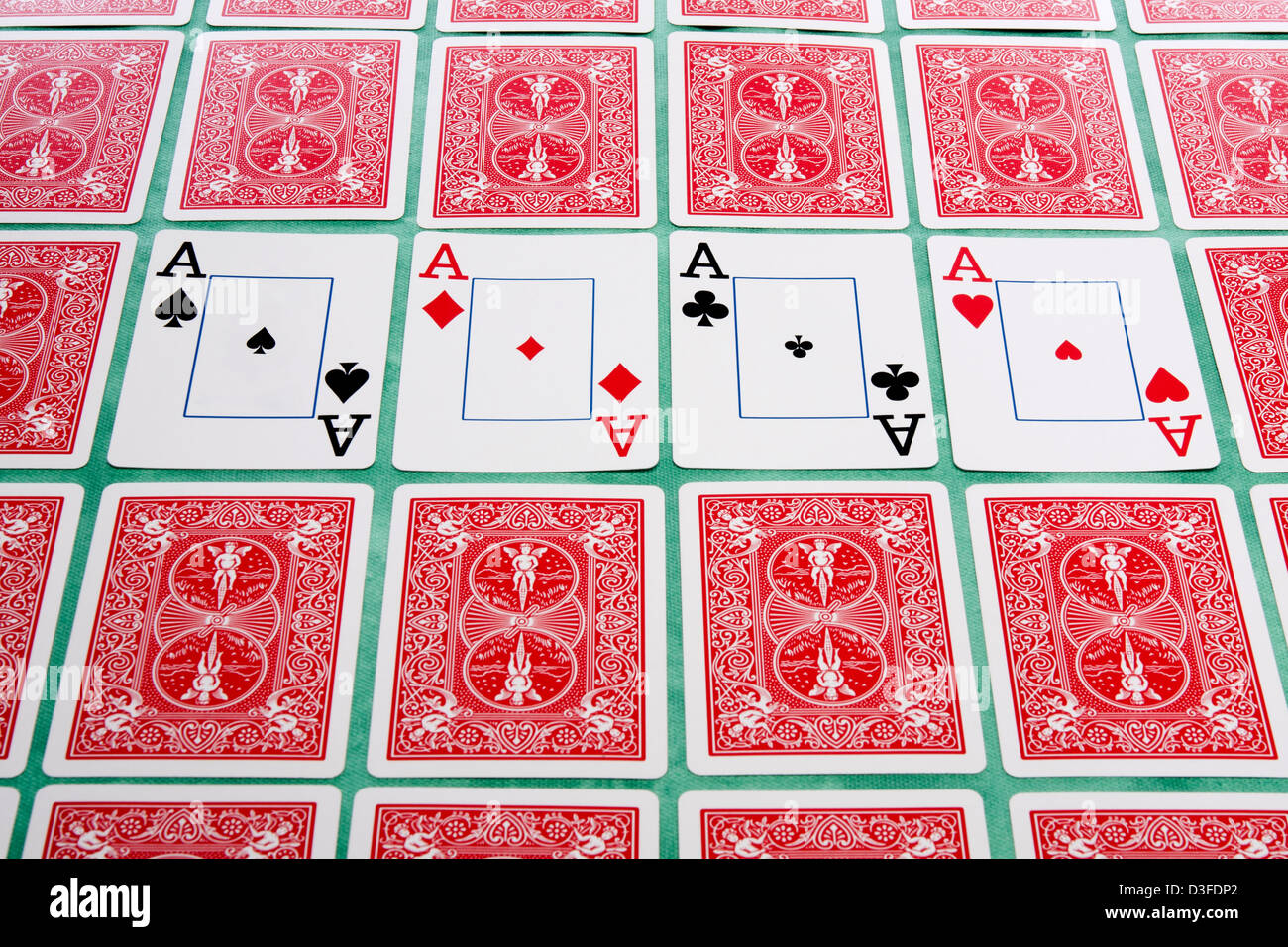 Close up view of a bunch of flipped playing cards spread on a green ...