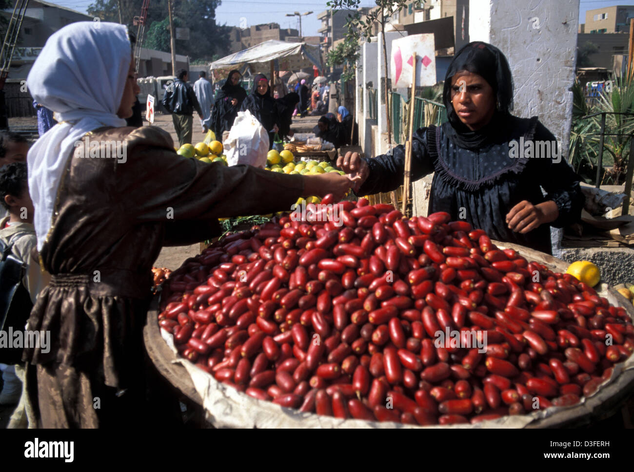 Woman selling dates from a street stall in Minya Egypt Stock Photo - Alamy