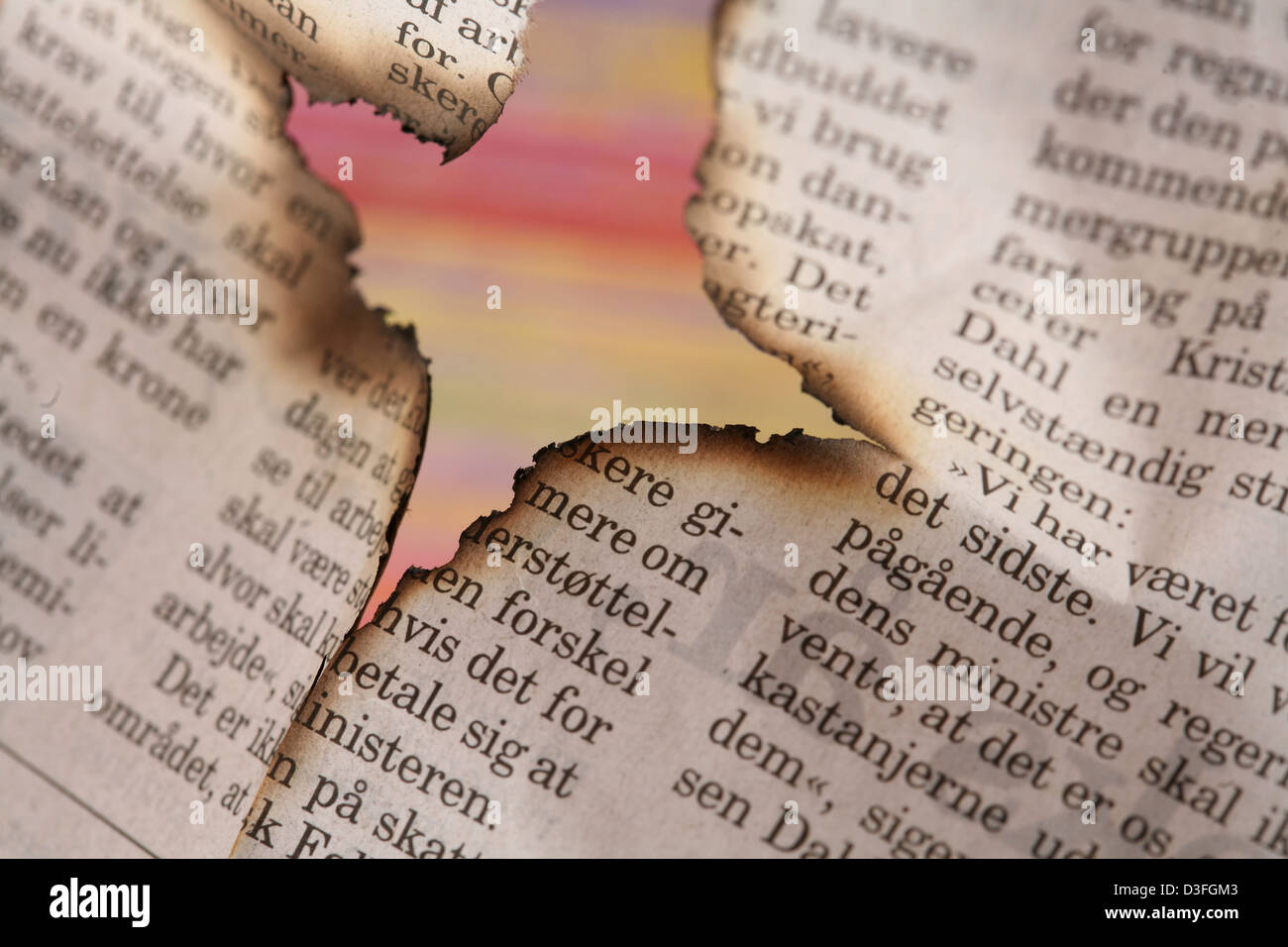 burnt newspaper (in danish) and colorful background Stock Photo - Alamy
