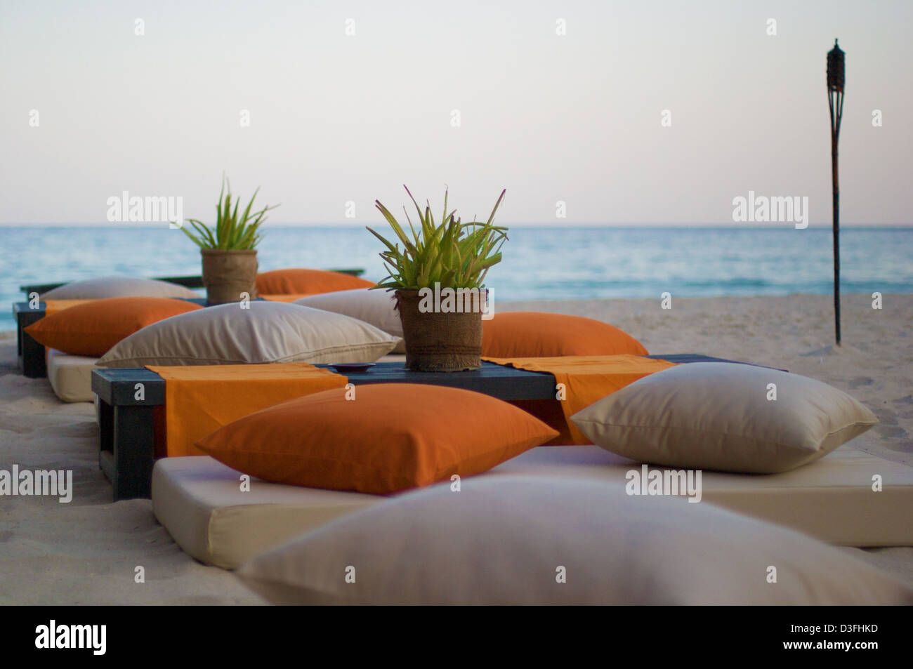 Low seating set up on the beach at sunset at Six Senses Zighy Bay, Oman ...