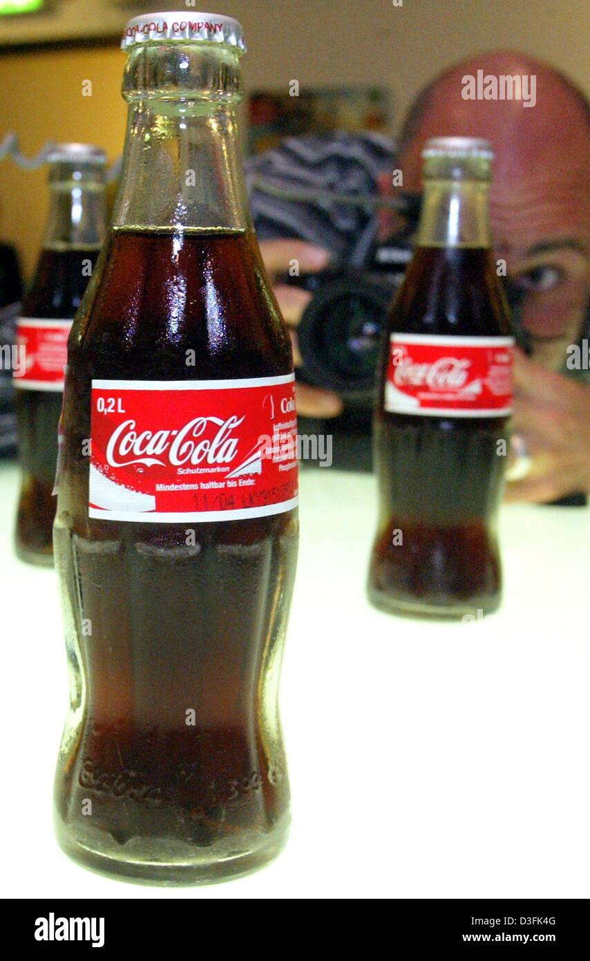 (dpa) - A photographer takes a picture of Coca-Cola bottles at the ...