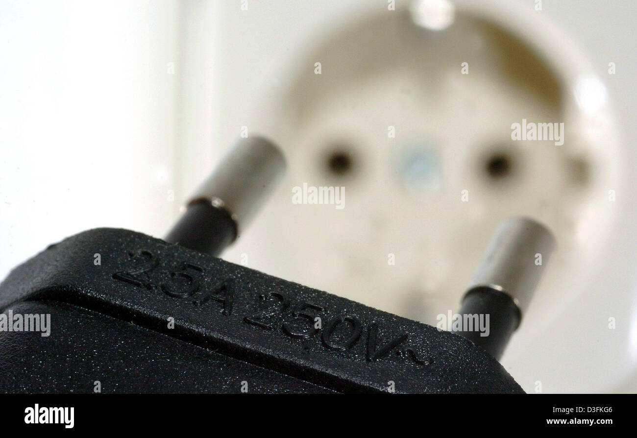 (dpa) - A plug featuring the inscription 250 volts is put into a power ...