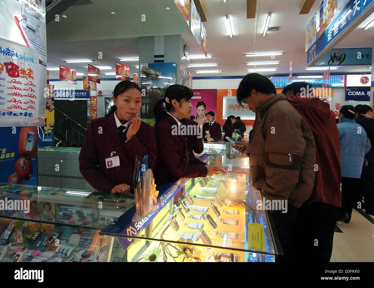 (dpa) - Customers look at mobile phones in a phone shop in Changchun ...
