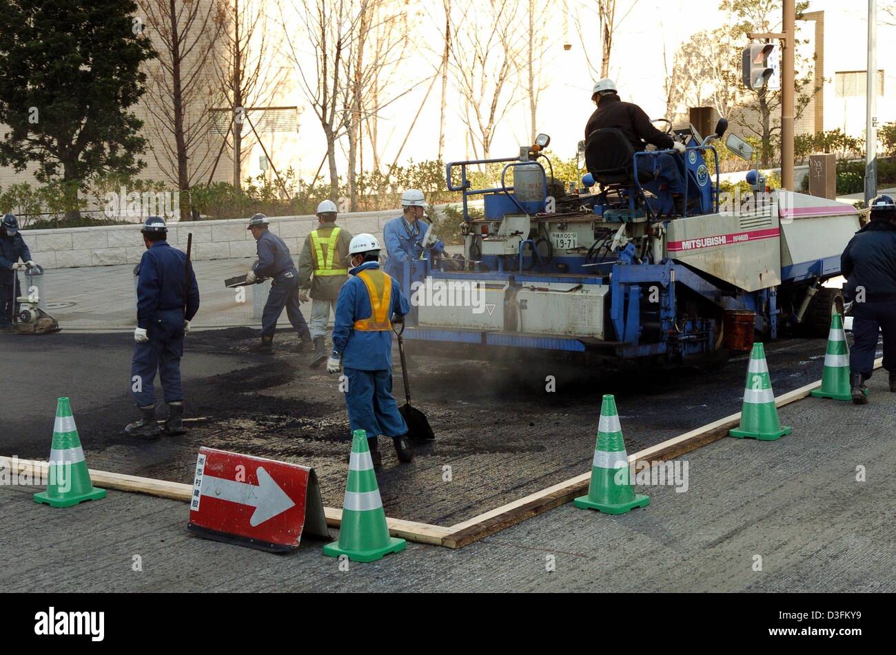 (dpa) - Roadmen asphalt a street in the city of Yokohama, Japan, 14 ...