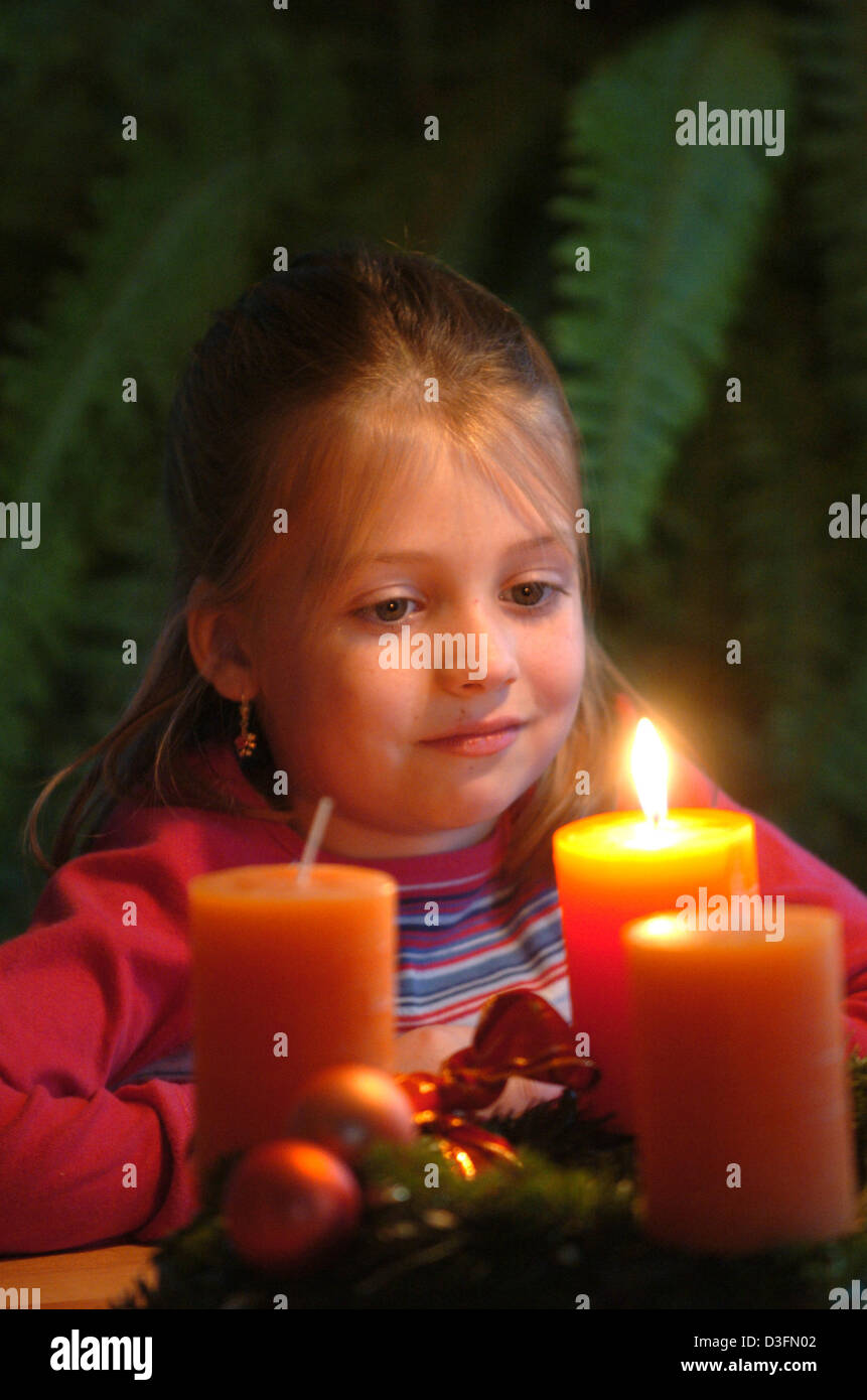 (dpa) - The little Lea looks dreamily into the flame of a candle on an ...
