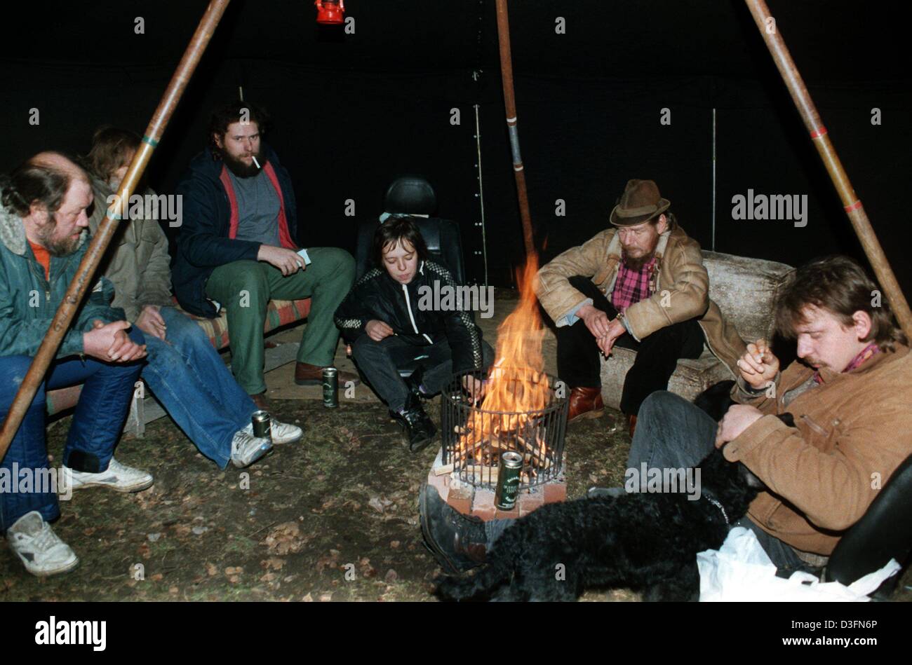 (dpa files) - A group of homeless people huddles around a fire and ...
