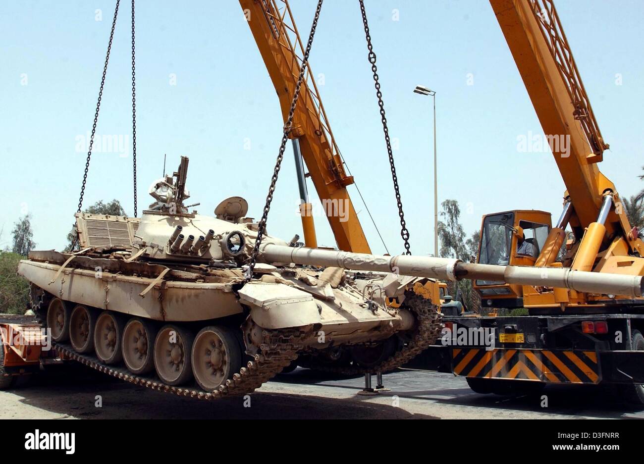 (dpa) - Two cranes remove the wreck of an Iraqi T 62 main battle tank ...
