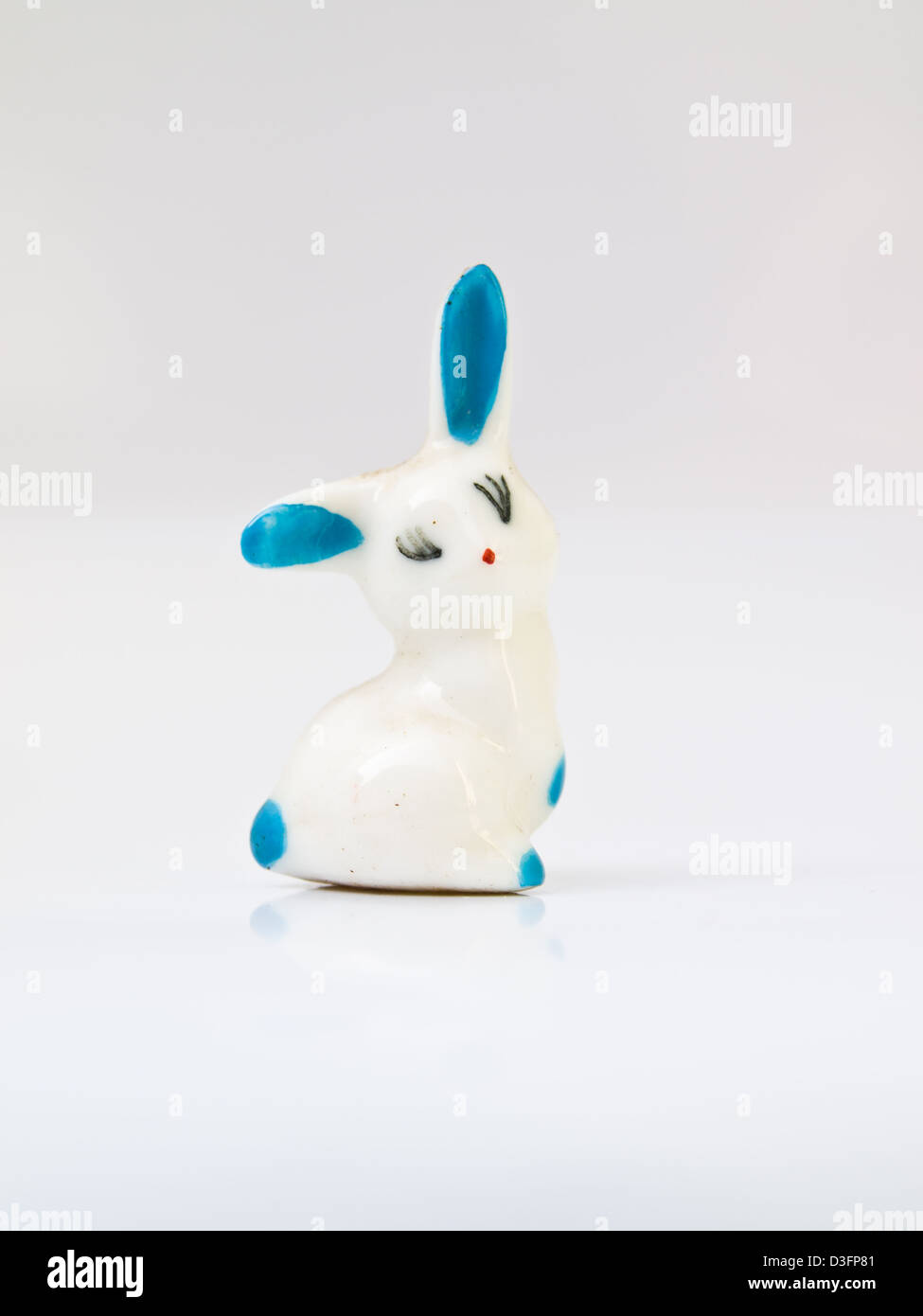 A ceramic doll of white rabbit with light blue spots isolated on white ...
