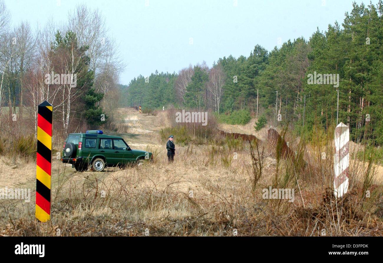 (dpa) - A German customs officer stands with his vehicle between the ...