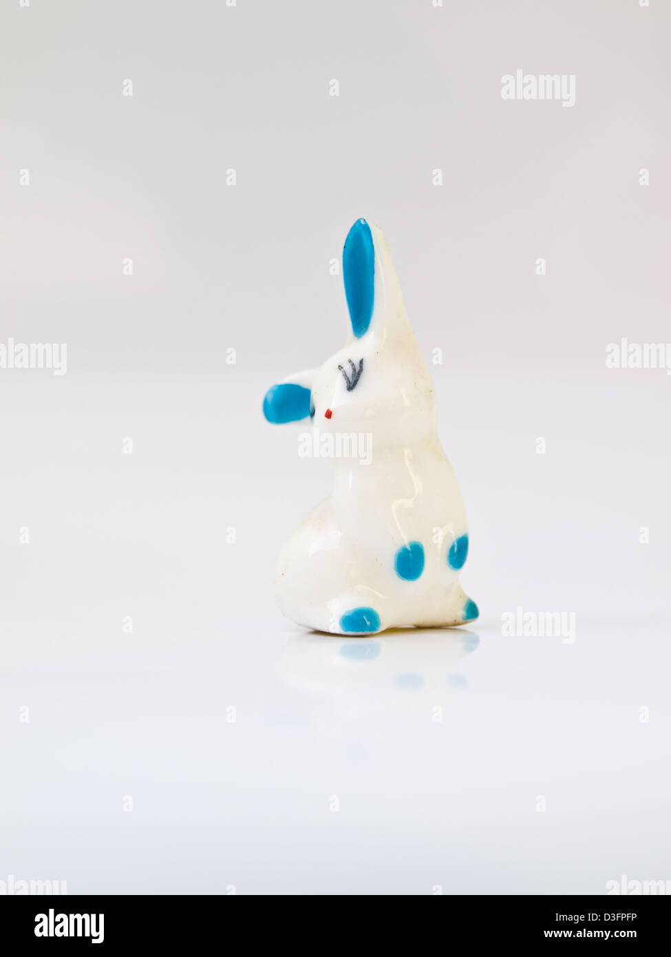 A ceramic doll of white rabbit with light blue spots isolated on white ...