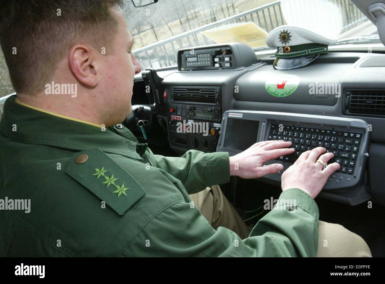 (dpa) - An officer of the German border guard (BGS) sits in a police ...