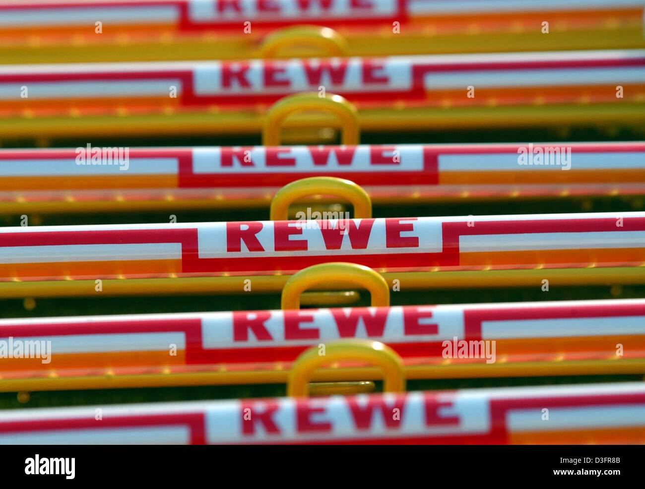 (dpa) - The corporate logo of Rewe is displayed on trolleys in a ...